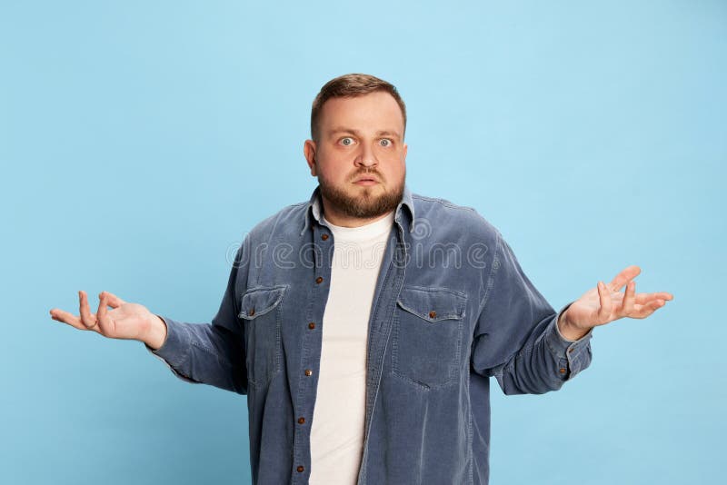 Nice-looking Man Wearing Jeans Jacket Spreading Hands and Looking at ...