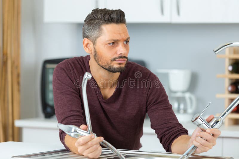 Confused Man Fixing Tap with Wrench in Kitchen Stock Photo - Image of ...