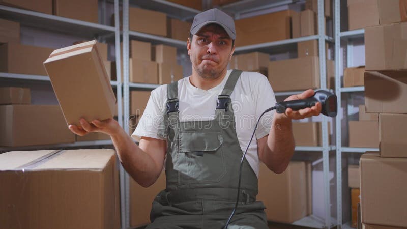 A Confused Man in a Loader S Uniform Scans Boxes with a Barcode Scanner ...