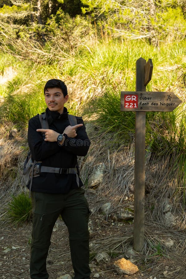 Confused Man Pointing with His Hands in Two Directions in Nature Stock ...