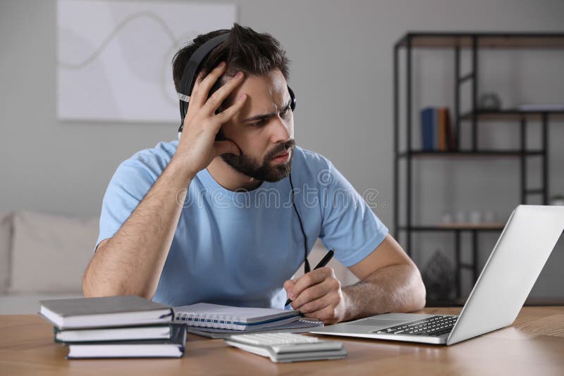 Confused Young Man Watching Webinar at Table in Room Stock Image ...