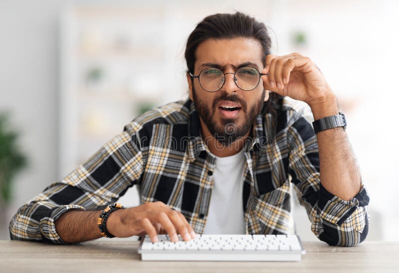 Confused Middle-eastern Man Programmer Sitting at Worktable, Touching ...