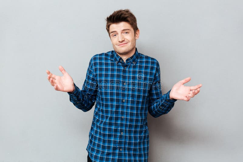 Confused Young Man Standing Over Grey Wall Stock Photo - Image of ...