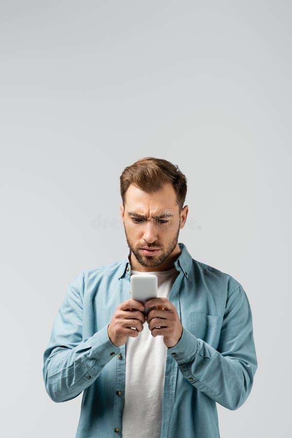 Confused Young Man Using Smartphone Isolated Stock Photo - Image of ...