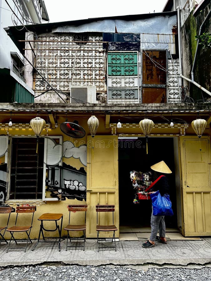 Hanoi, Vietnam- July 28, 2024: Street Vendor Outside Graffiti Wall ...