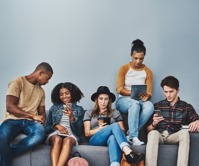 Always Connected, always Available. Studio Shot of Young People Sitting on a Sofa and Using ...