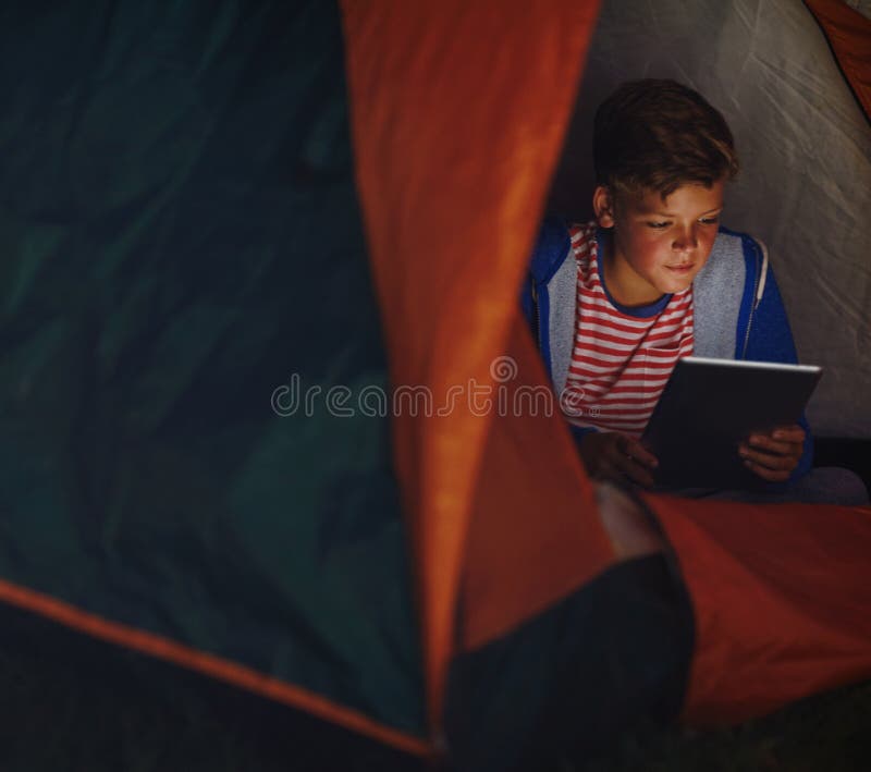 Connected while Out Camping. a Young Boy Using a Digital Tablet while ...