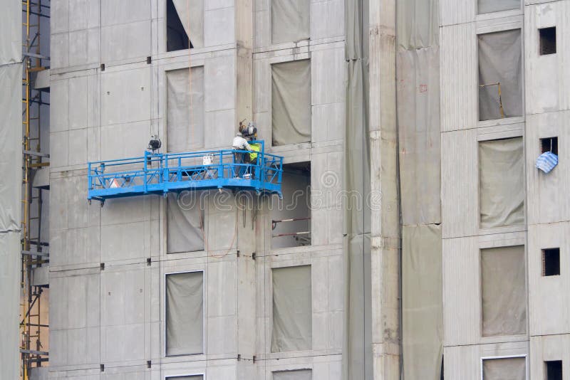 Construction Baskets Blue Next To the Building with Workers Stock Photo ...