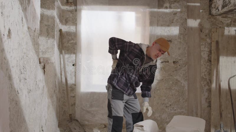 Construction Builder Worker on a Building Site Lifting a Heavy Bag ...