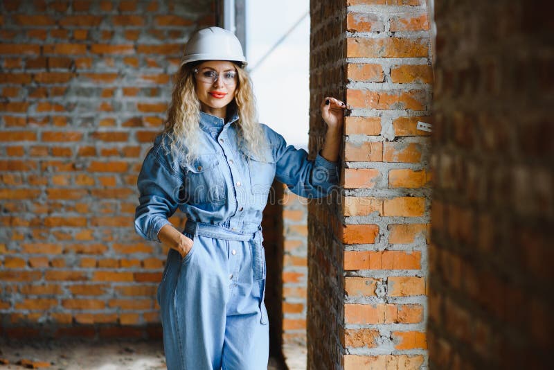 Construction Concept. Pretty Female Builder in Overalls and Helmet ...