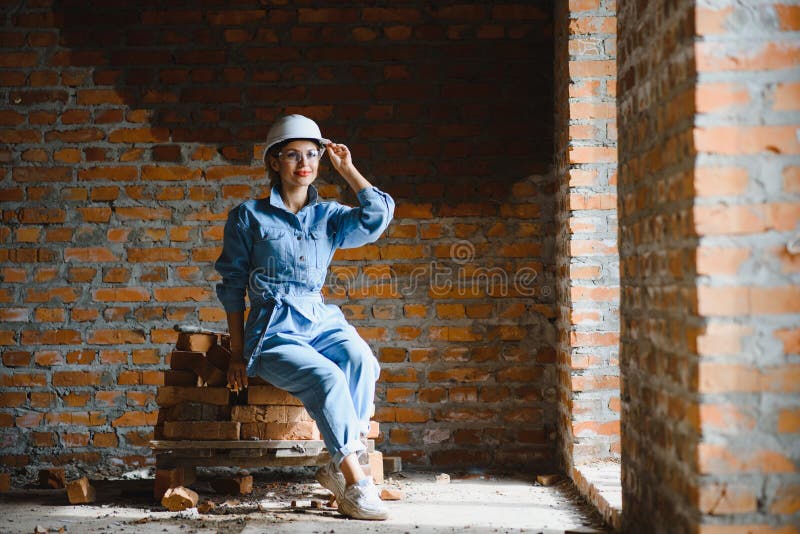 Construction Concept. Pretty Female Builder in Overalls and Helmet ...