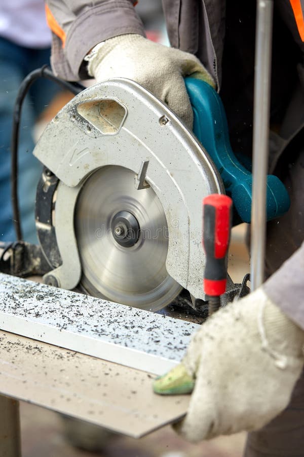 A Construction Contractor Worker Using a Worm-driven Hand-held Circular ...