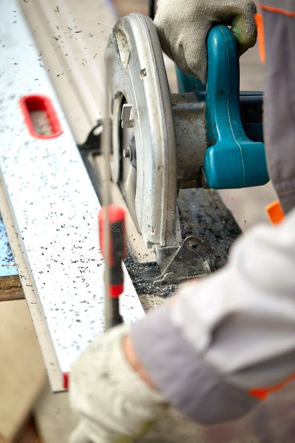 A Construction Contractor Worker Using a Worm-driven Hand-held Circular ...