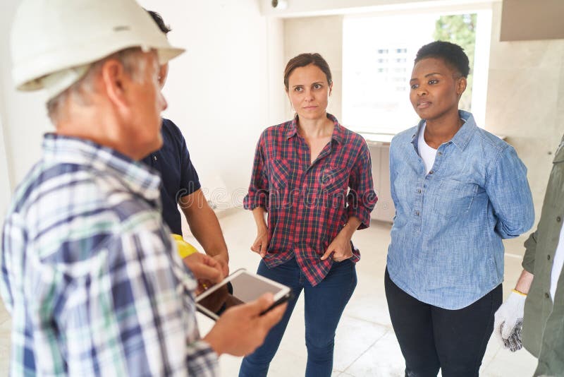 Construction Coworkers Discussing with Senior Contractor while Standing ...