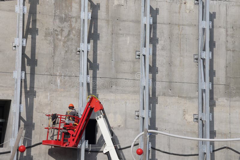 Construction Cradle with a Worker on the Wall of a Building Under ...