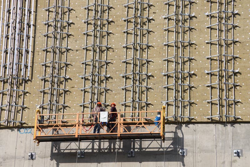 Construction Cradle with Workers on the Wall of a Building Under ...