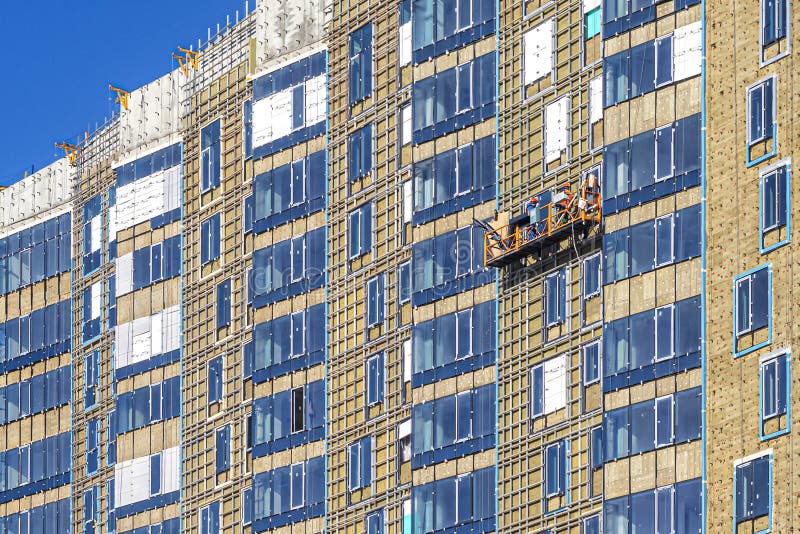 Construction Cradle with Workers on the Wall of a Building Under ...