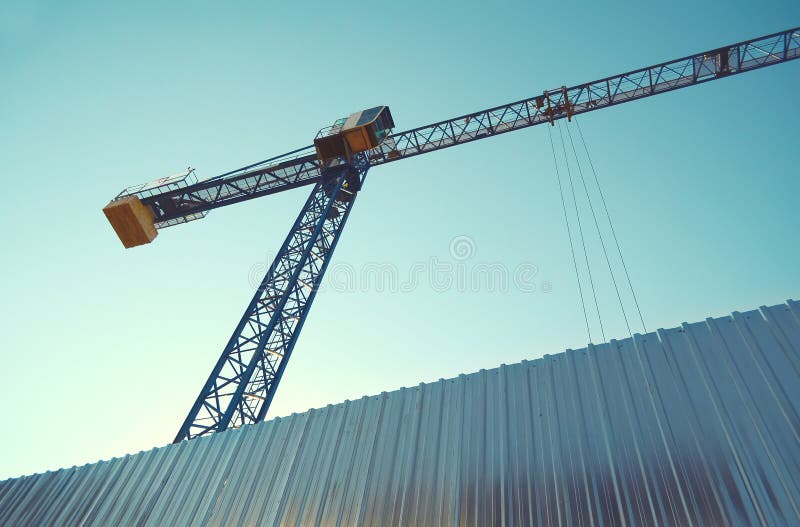 Construction Crane Behind Tin Fence on the Cloudless Sky, the View from ...