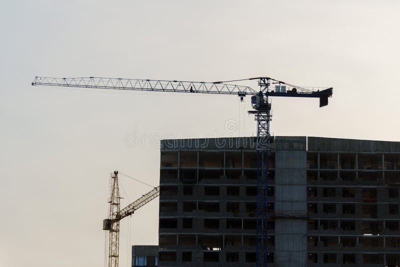 Construction Cranes on Top of a Building Under Construction. the Cranes ...