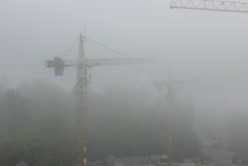 Construction Crane Hidden in the Fog at a Construction Site. Building ...
