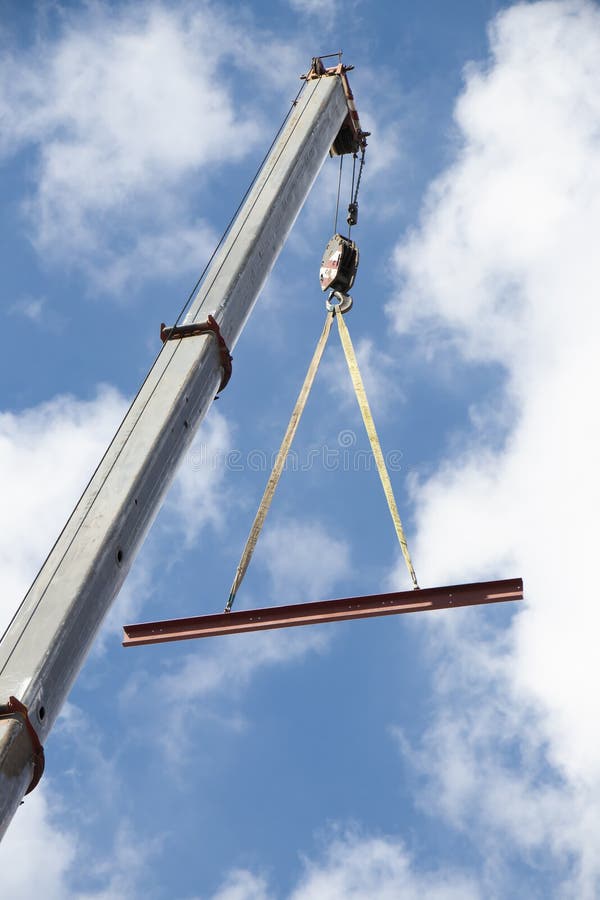 Construction Crane with a Hook and a Metal Profile Hanging on Ropes ...