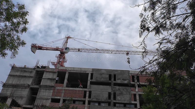 Construction Crane Lifting Building Materials at a Construction Site ...