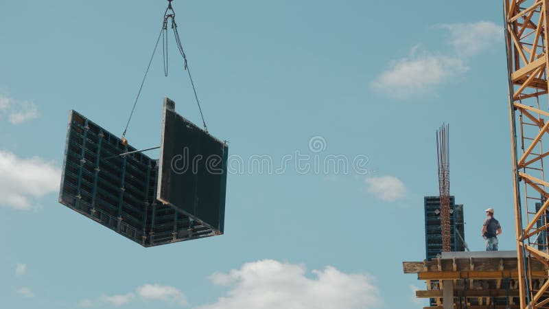 Construction Crane Lifting Large Panel on Building Site. a Crane is ...