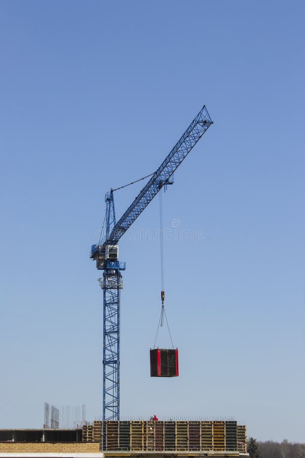 A Construction Crane Moves the Load. Building Materials on Pallets ...