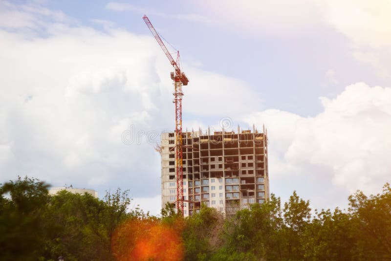 Construction Crane in Rays of Bright Sun. House Under Construction and ... Construction Crane in Rays of Bright Sun. House Under Construction and ...