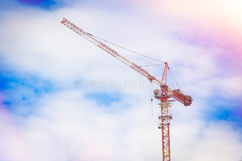 Construction Crane in Rays of Bright Sun. House Under Construction and ...