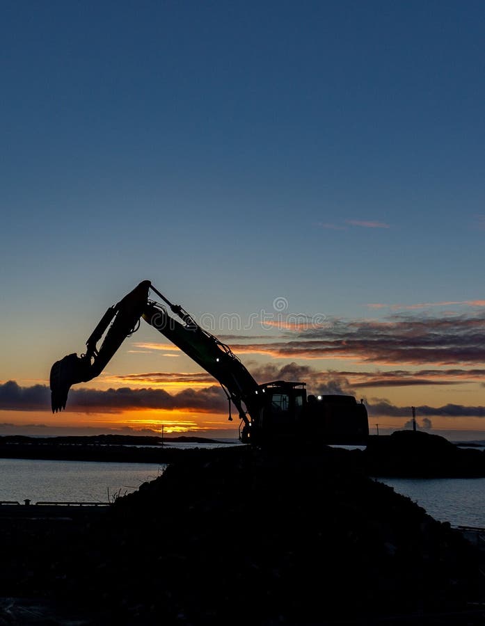 Construction Crane Seen Hard at Work Moving Sand and Rock in Front of a ...