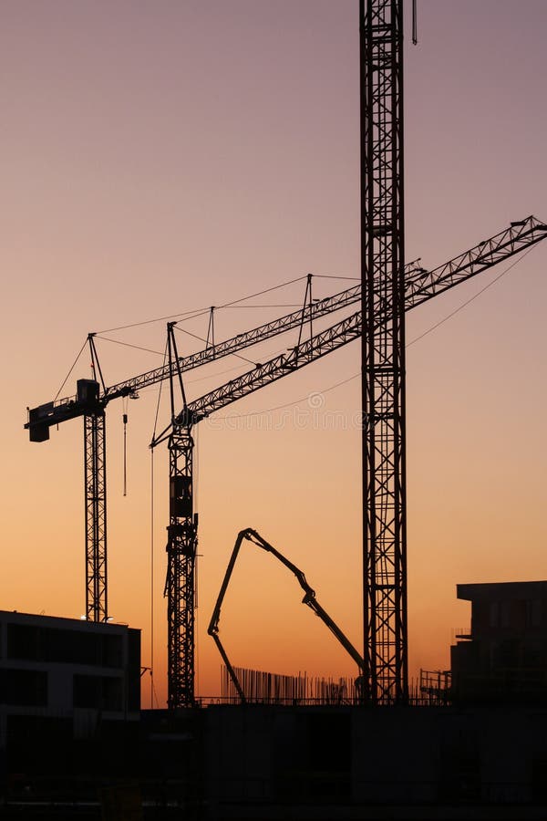 Construction Cranes Seen Against the Backdrop of the Setting Sun Stock ...