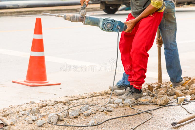 Construction Drilling Repair Worker on Road Surface with Heavy Duty ...