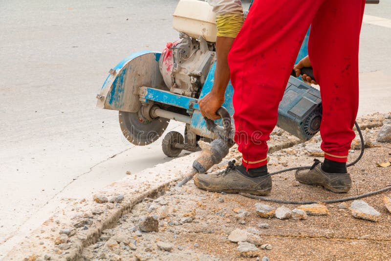 Construction Drilling Repair Worker on Road Surface with Heavy Duty ...