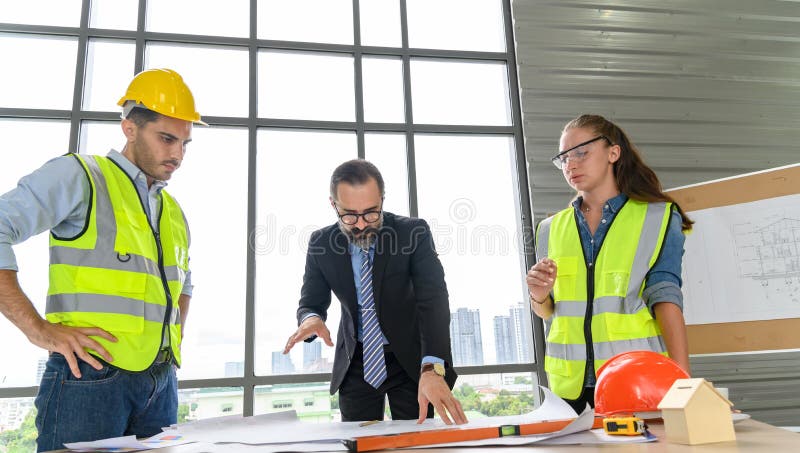 Construction Engineer and Architect in Vest and Helmet Discussing ...