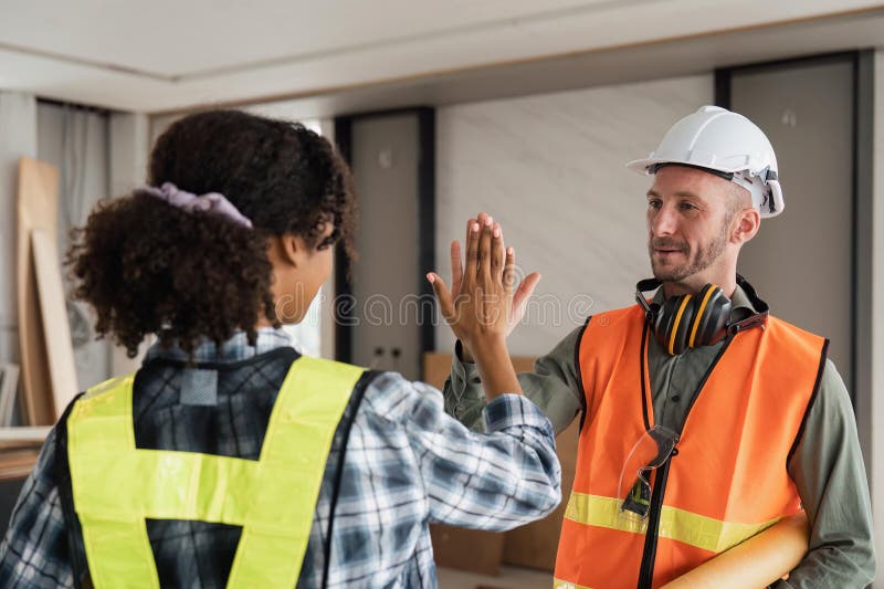 Construction Engineer with Blueprint Making High Five while Standing on ...