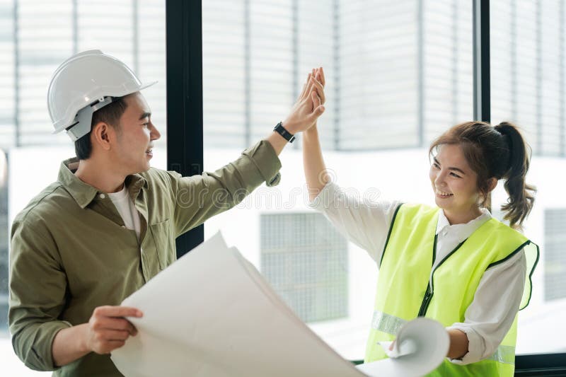 Construction Engineer with Blueprint Making High Five while Standing on ...