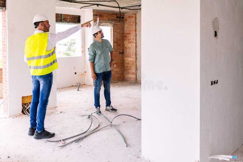 Construction Engineer Discussing with Architect Worker at Indoor ...