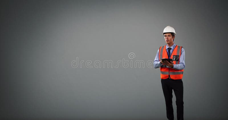 Construction Engineer in Hard Hat and Safety Vest Using Tablet, Focused ...