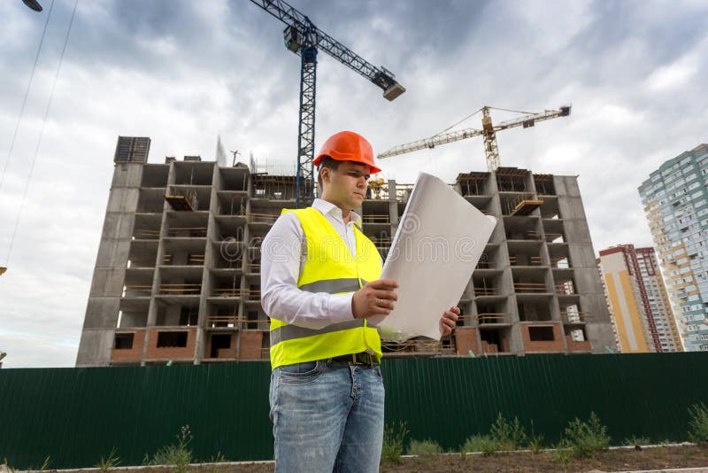 Portrait of Construction Engineer Looking at Blueprints on Building ...