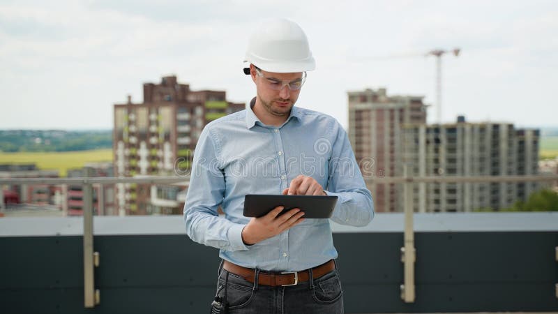 Construction Engineer Using Tablet for Project Supervision on Rooftop ...