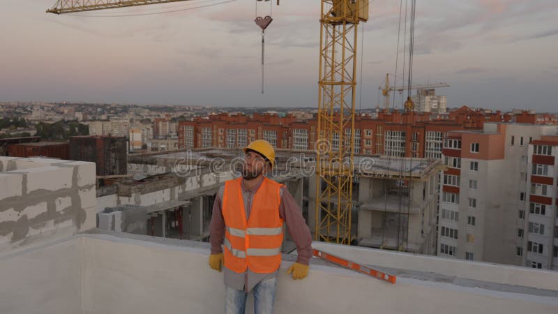 Construction Worker Pointing Upwards at Building Site with Cranes and ...