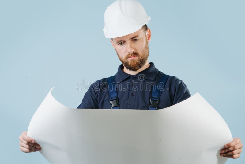Construction Engineer in a White Helmet and Blue Uniform with a Paper ...
