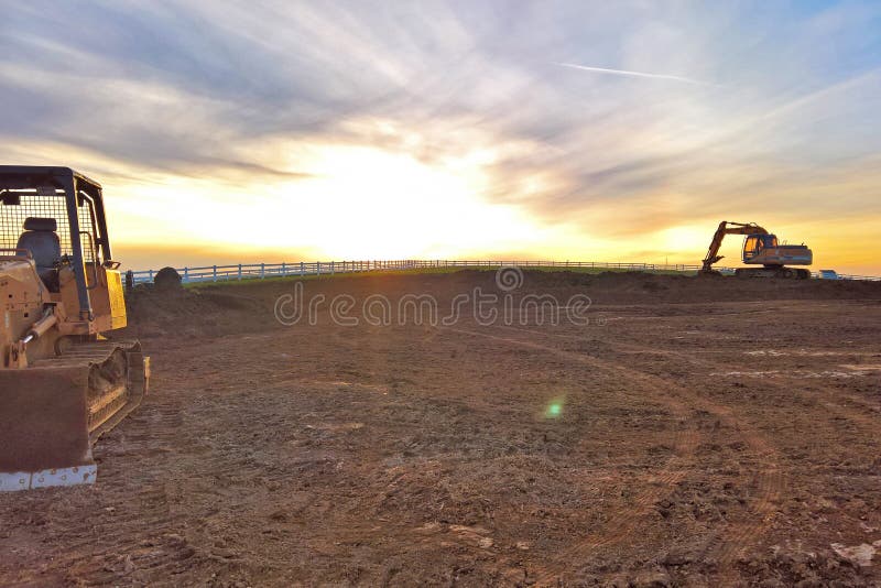 Construction Equipment in a Field during Sunset Stock Photo - Image of ...