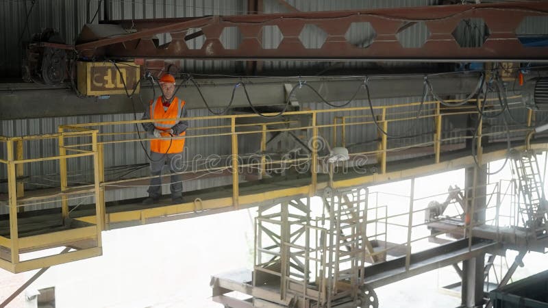 A Construction or Factory Worker Oversees Operations from a Catwalk ...