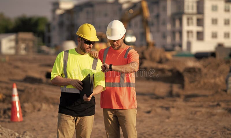 Construction Foreman and Civil Engineer at Work Checking Time Schedule ...