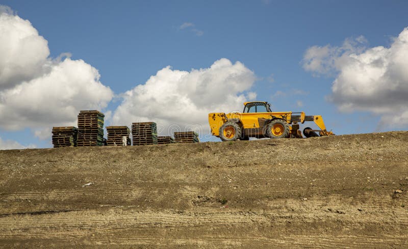 Construction Grading Equipment and Pallets on a Steep Hill Against a ...