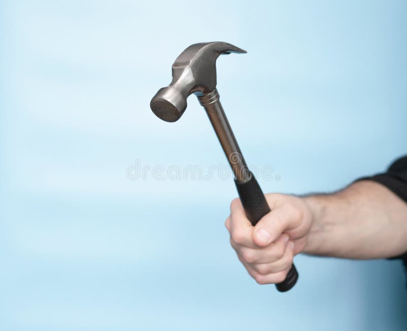 Construction Hammer in a Man S Hand on a Blue Background. Imitation of ...