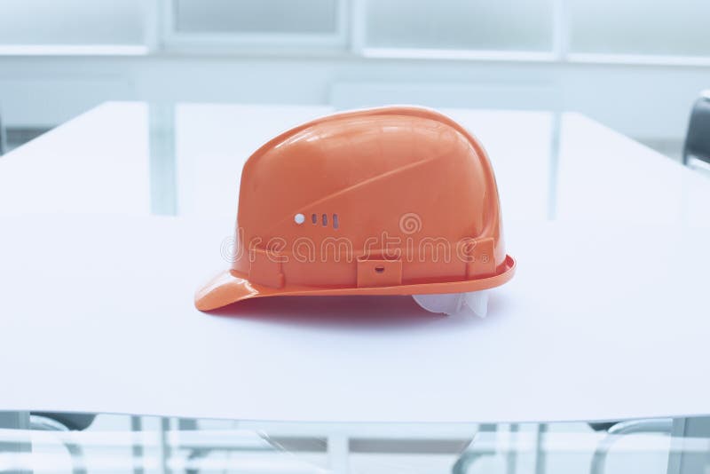 Construction Hard Hat Blueprints on Glass Table in Office Space. Close ...