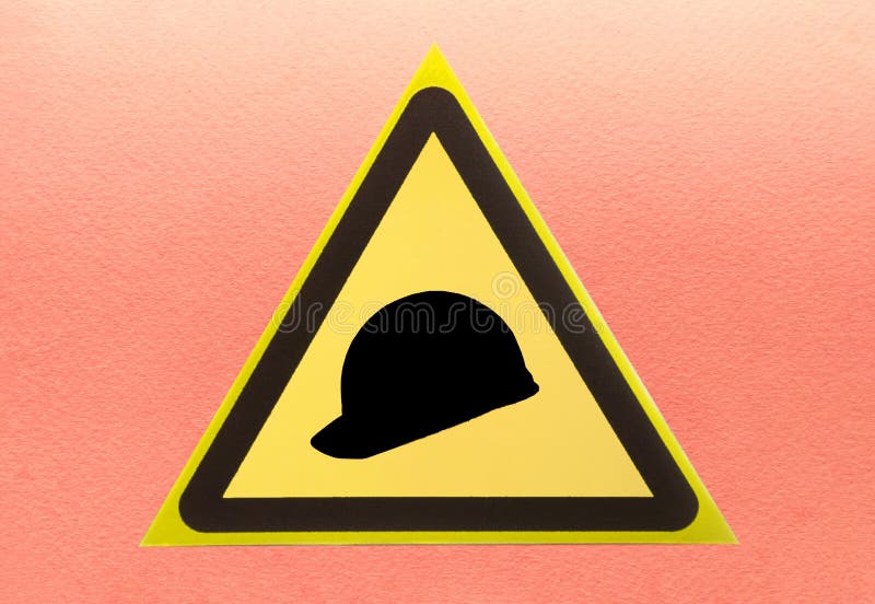 Construction Helmet in a Yellow Triangle Close-up on a Light Background ...